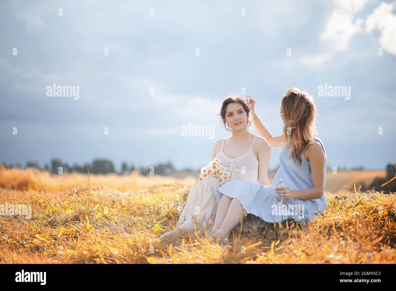 Two beautiful girls in dresses in autumn field have fun Stock Photo - Alamy