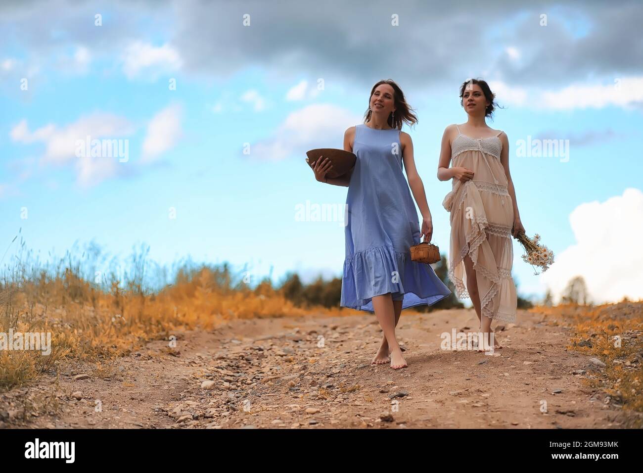 Two beautiful girls in dresses in autumn field with berries Stock Photo ...