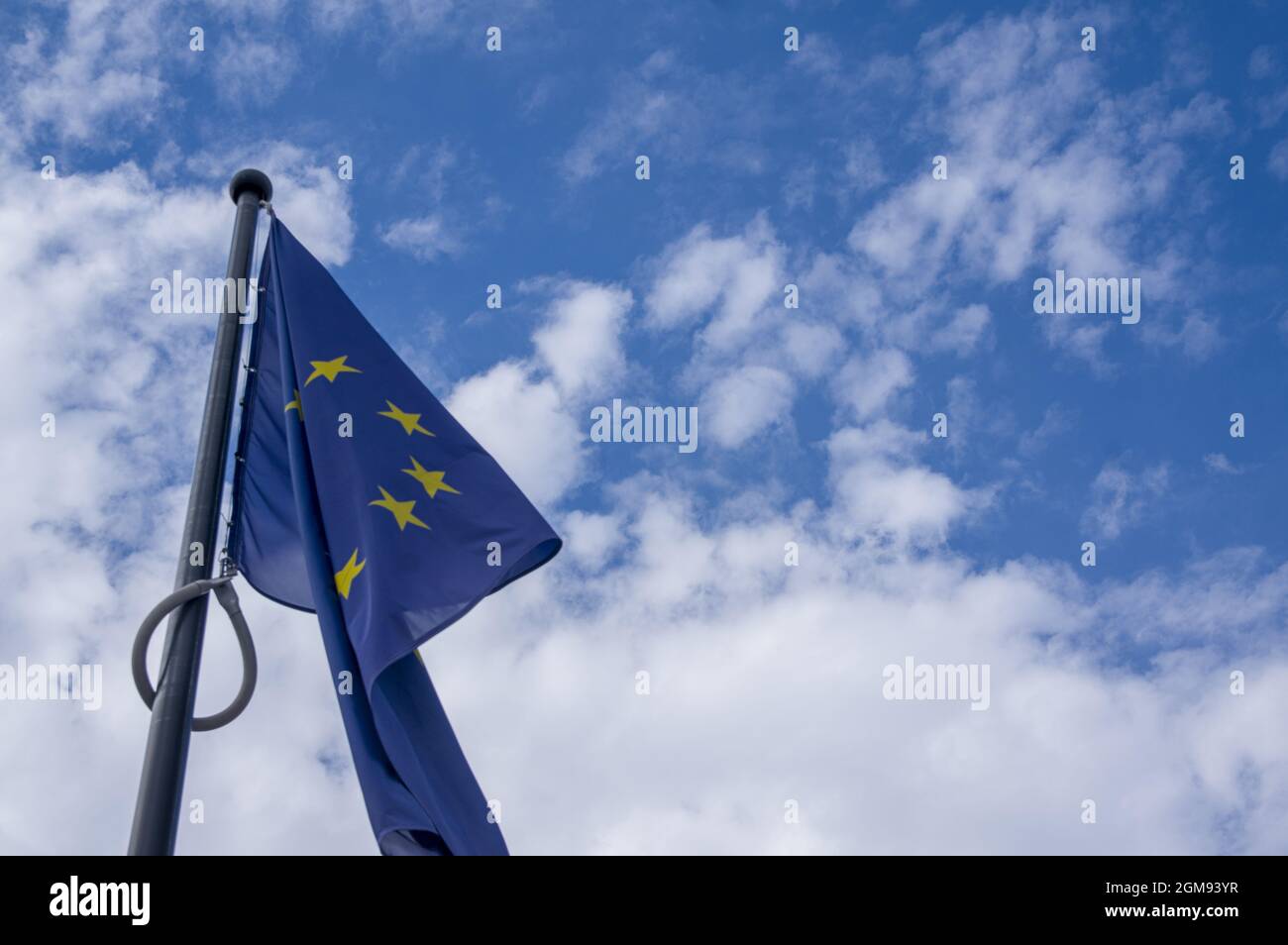 European Union flag on blue sky with white clouds background with copy ...