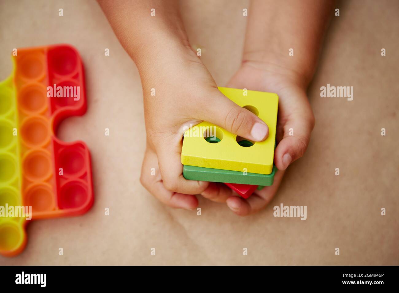 Baby plays with wooden sensory fidget toy. Top view. Colorful ...