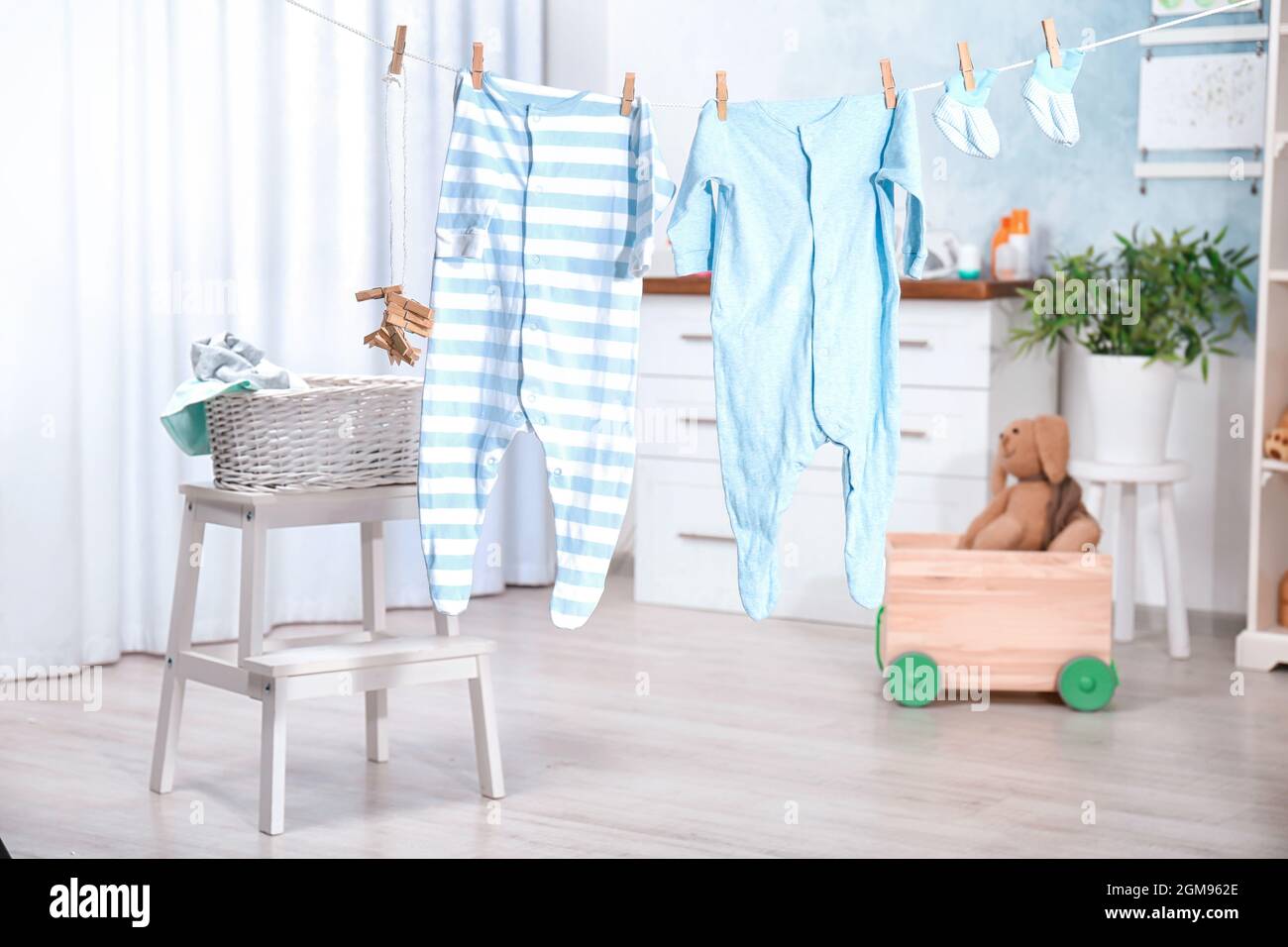 Children's clothes hanging on laundry indoors Stock Photo - Alamy