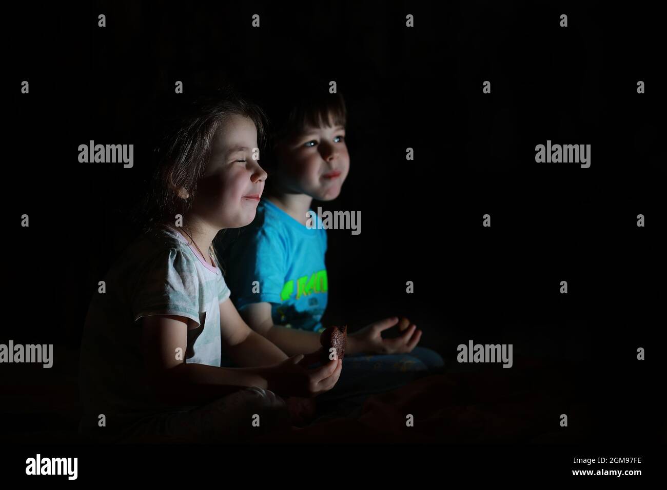 Small children in a dark room watching TV at night Stock Photo - Alamy