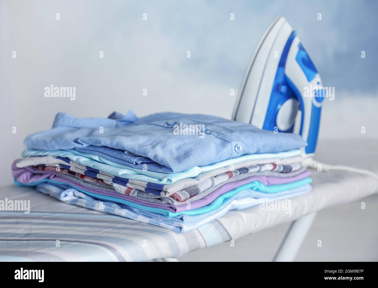 Stack of laundry on ironing board, indoors Stock Photo - Alamy