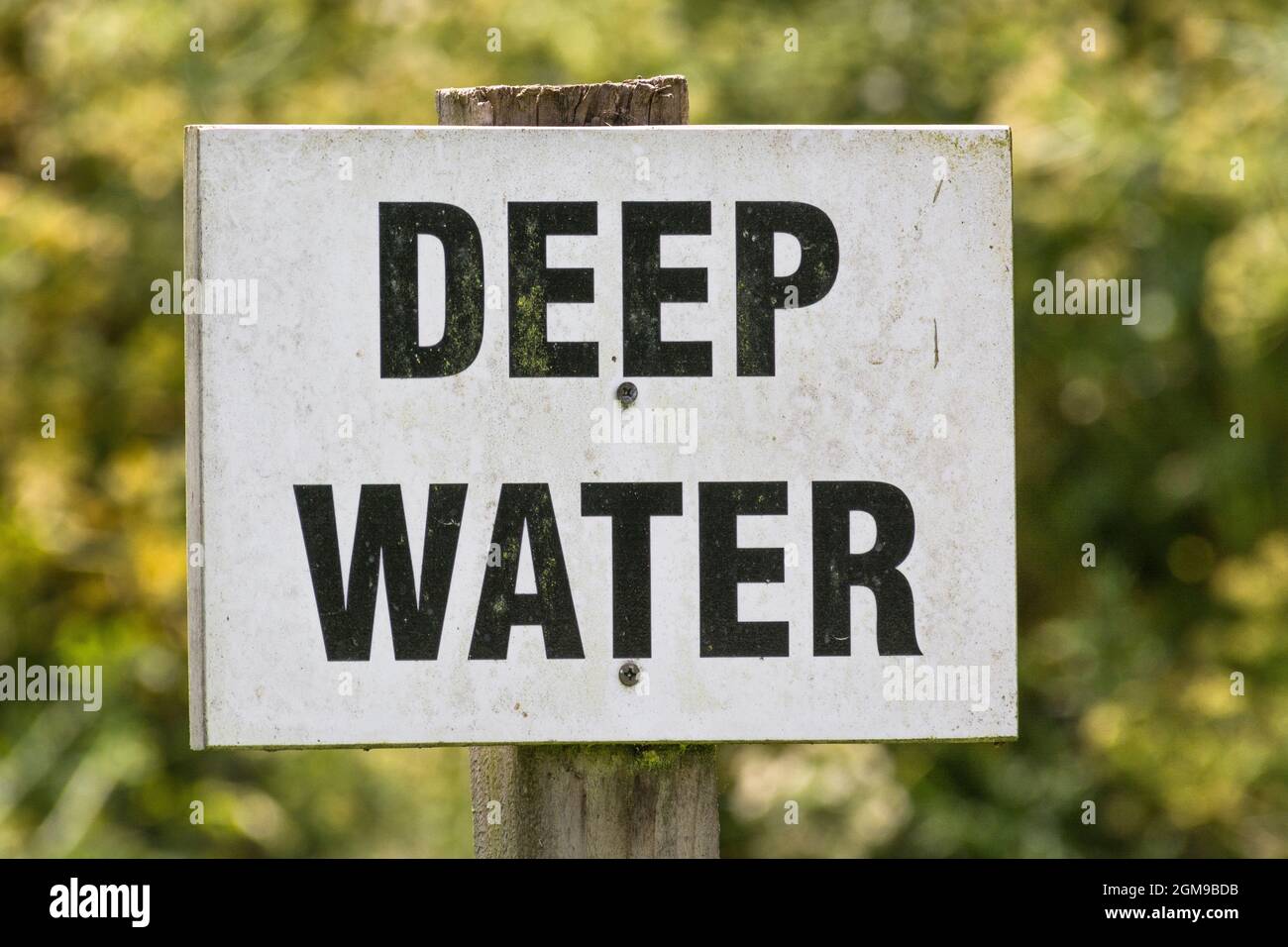 Deep Water warning sign at the side of a pond. Metaphor safety ...