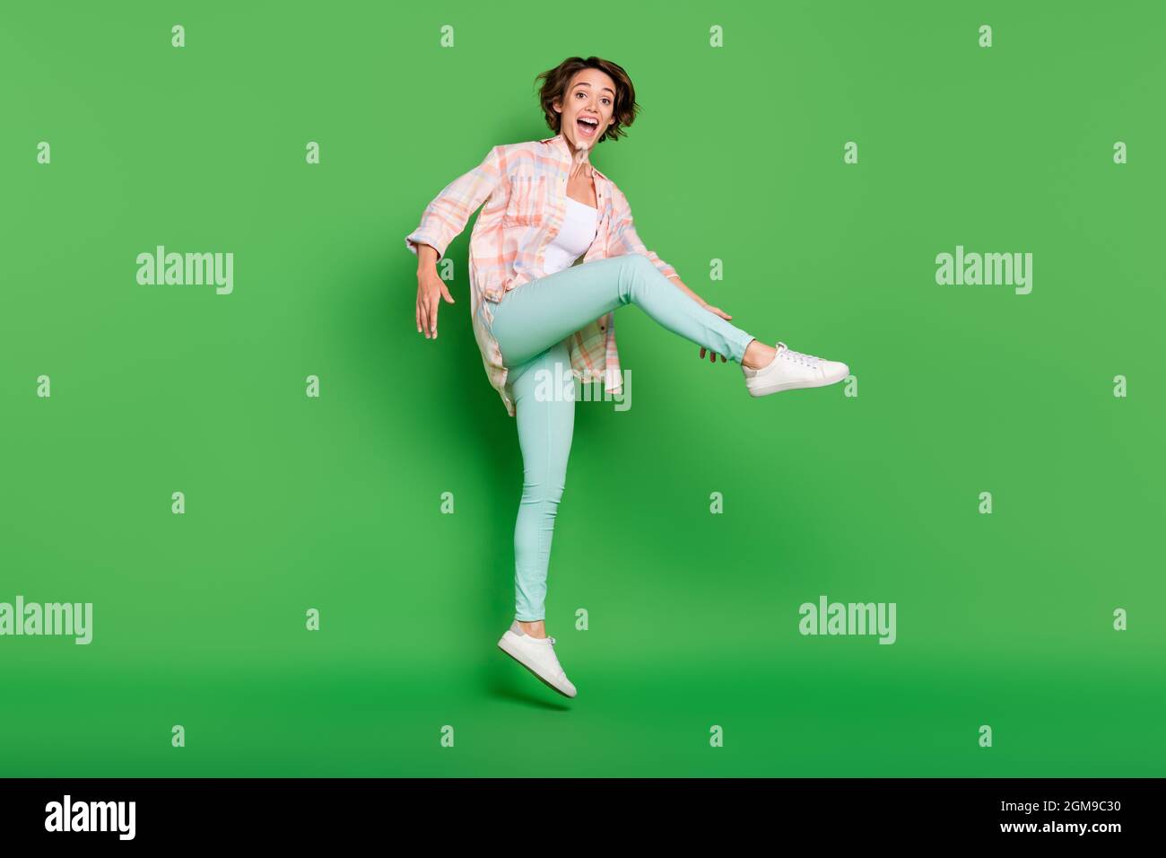 Full body photo of cheerful positive excited woman jump up hold hand ...