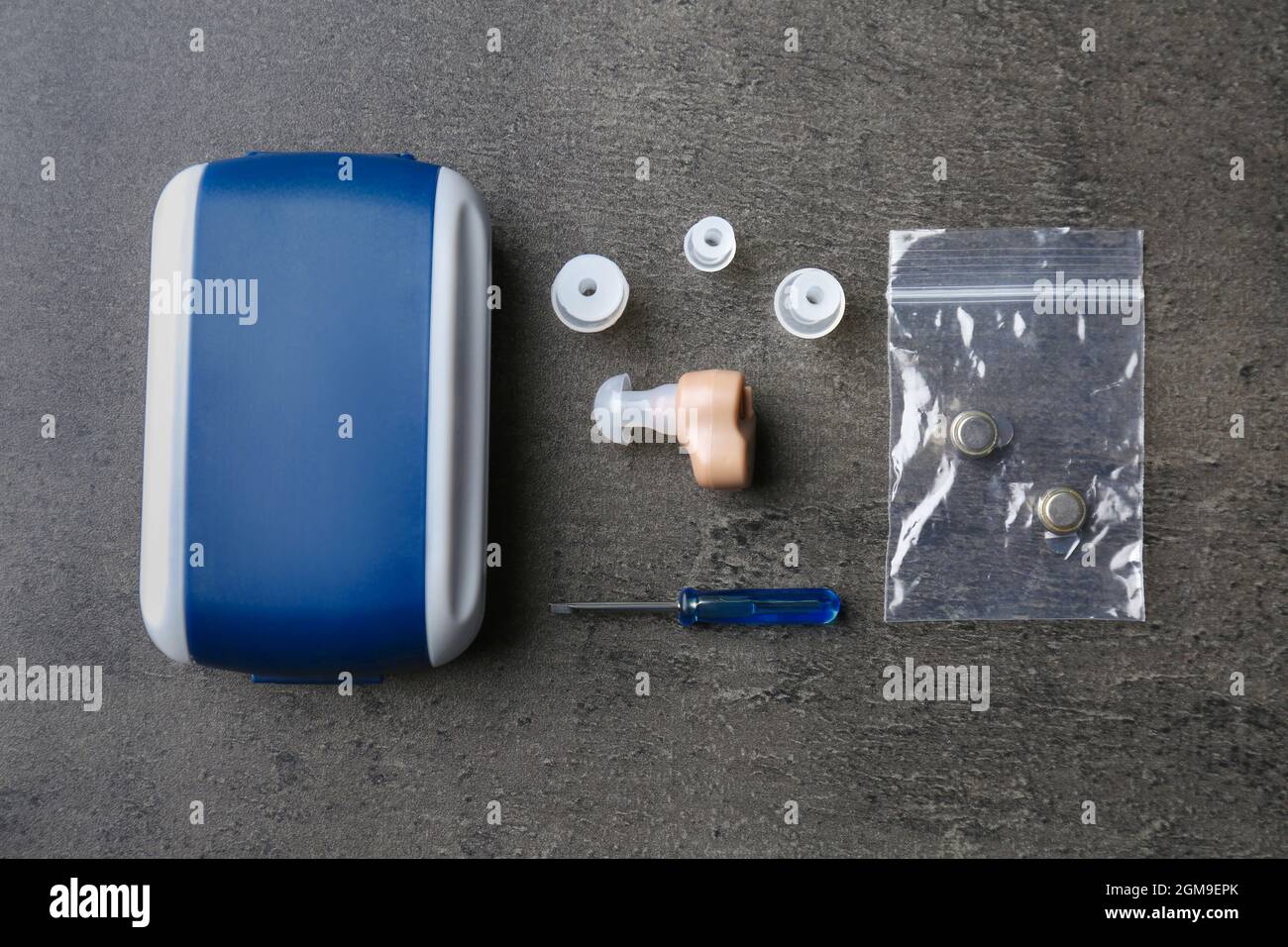 Composition with hearing aid and accessories on grey background Stock ...