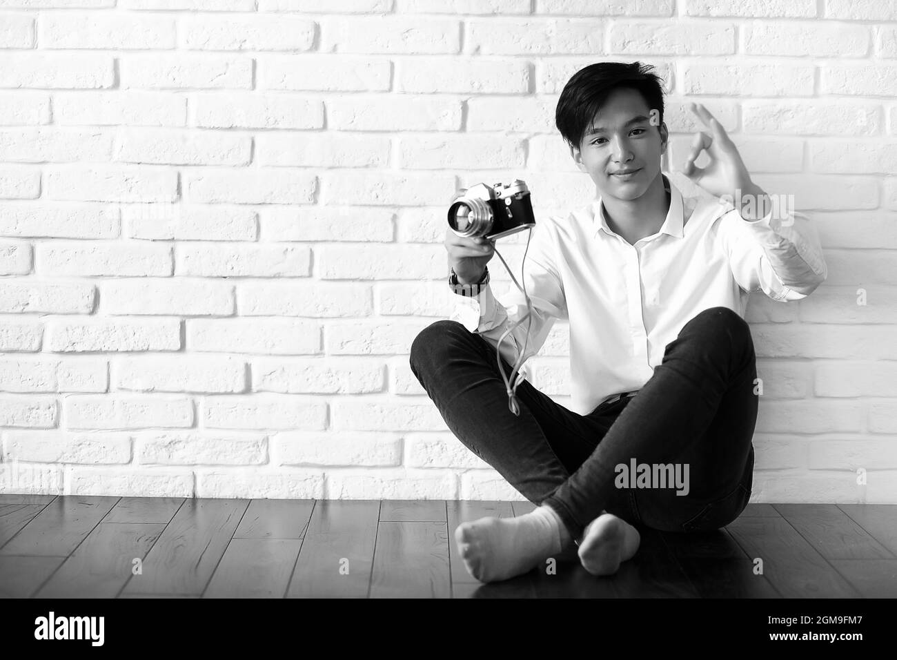 Asian young man uses a camera in the studio Stock Photo - Alamy