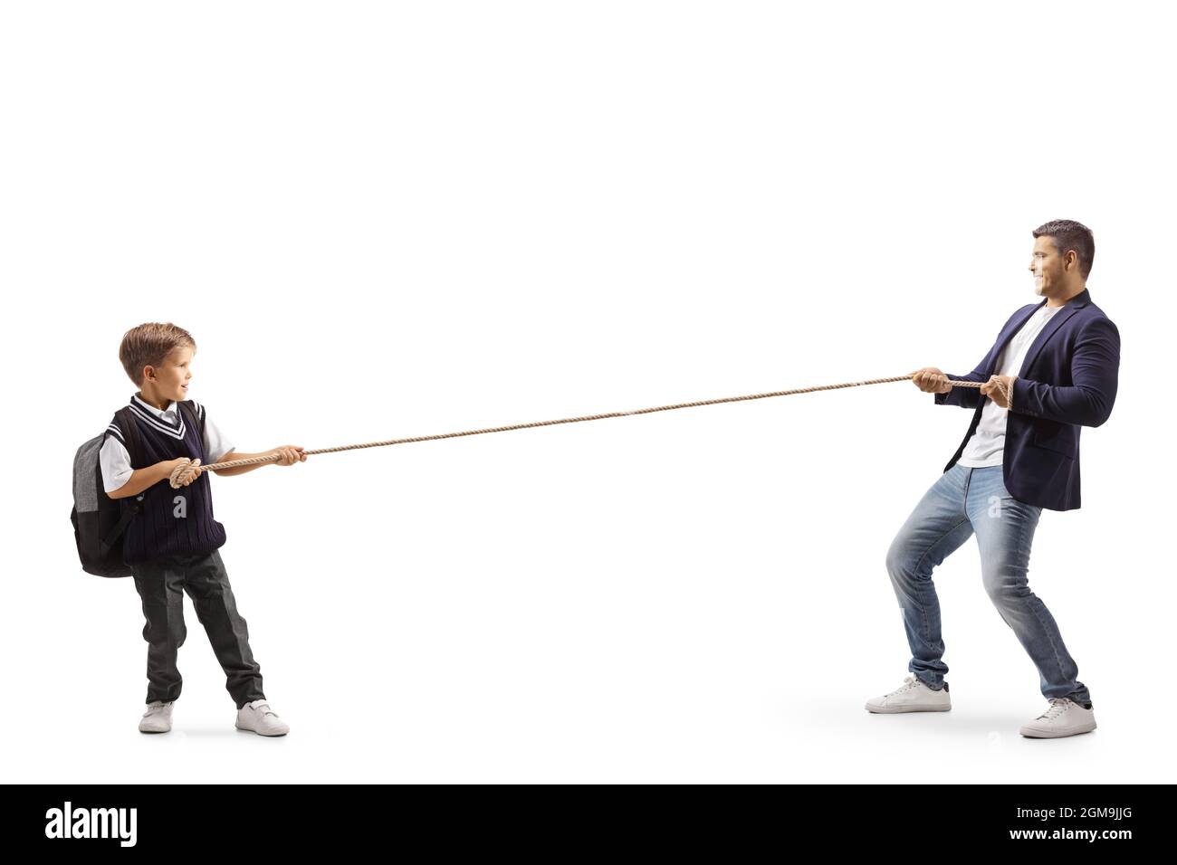 Full length profile shot of a little schoolboy and a young man pulling ...