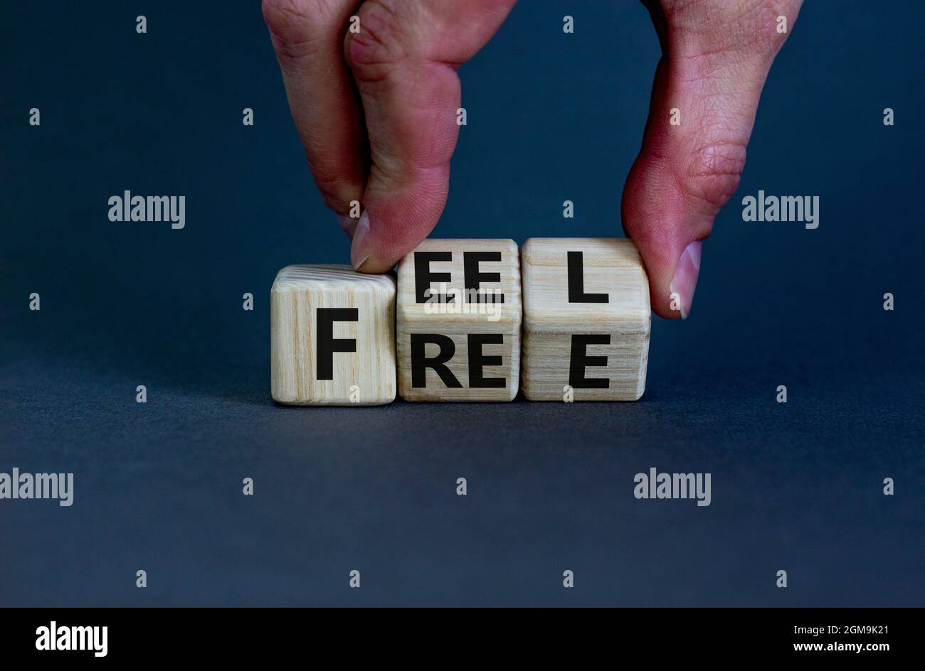 Feel free symbol. Businessman turns wooden cubes with concept words ...