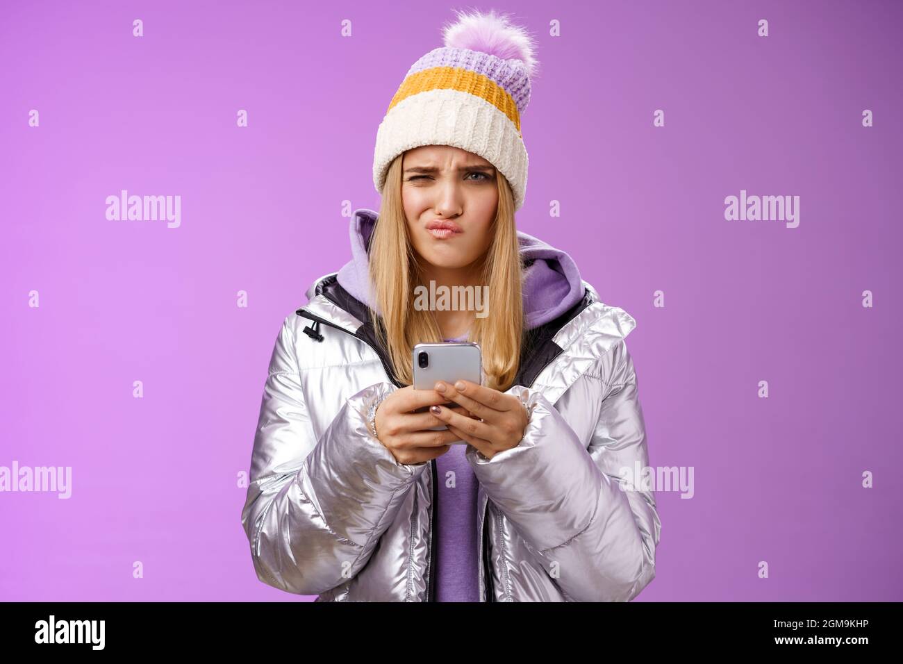 Perplexed displeased cute blond stylish girl unwilling anser message ...