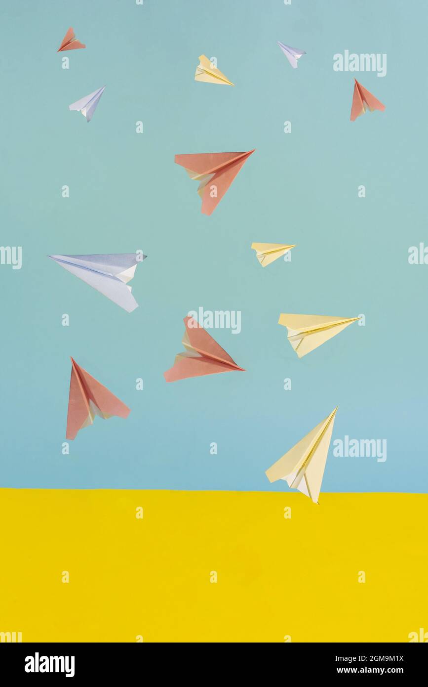Colored paper airplanes. Blue-yellow background Stock Photo - Alamy