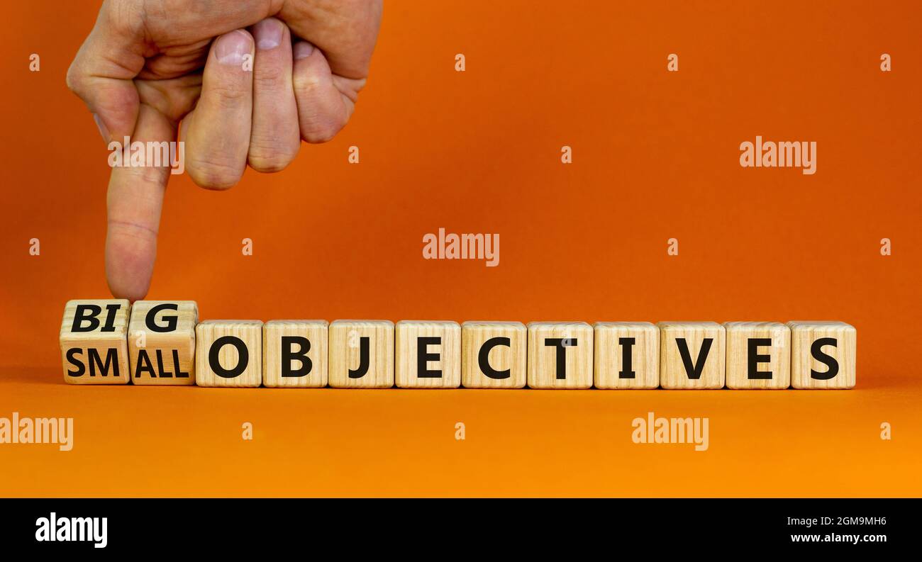 Big or small objectives symbol. Businessman turns wooden cubes, changes ...
