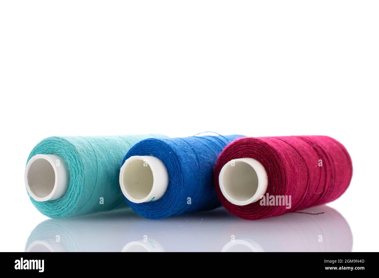 Three spools of colored thread, close-up, isolated on white Stock Photo ...
