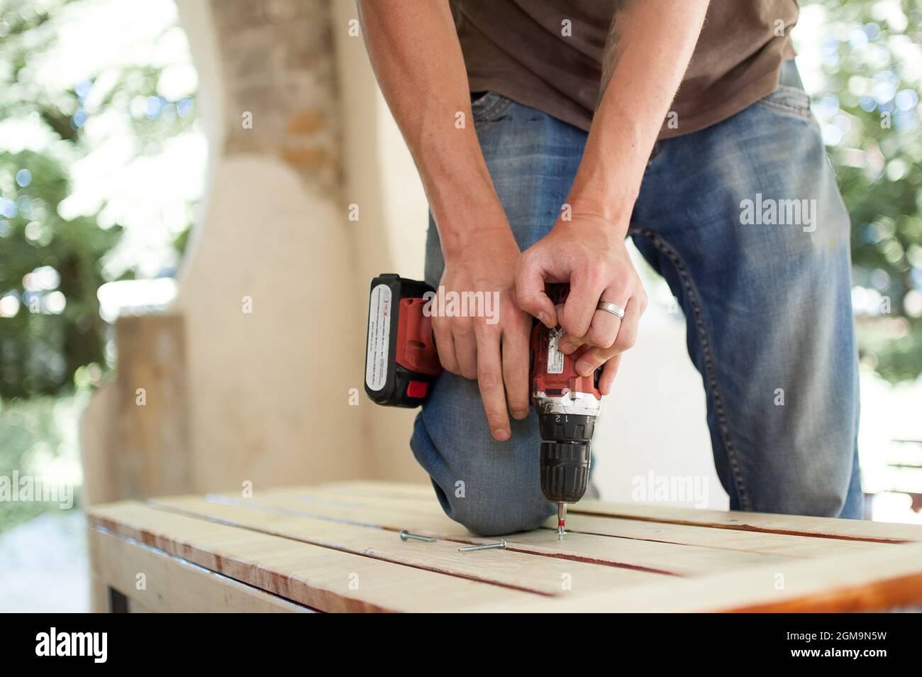 Skilled young male worker is using power screwdriver drilling during ...