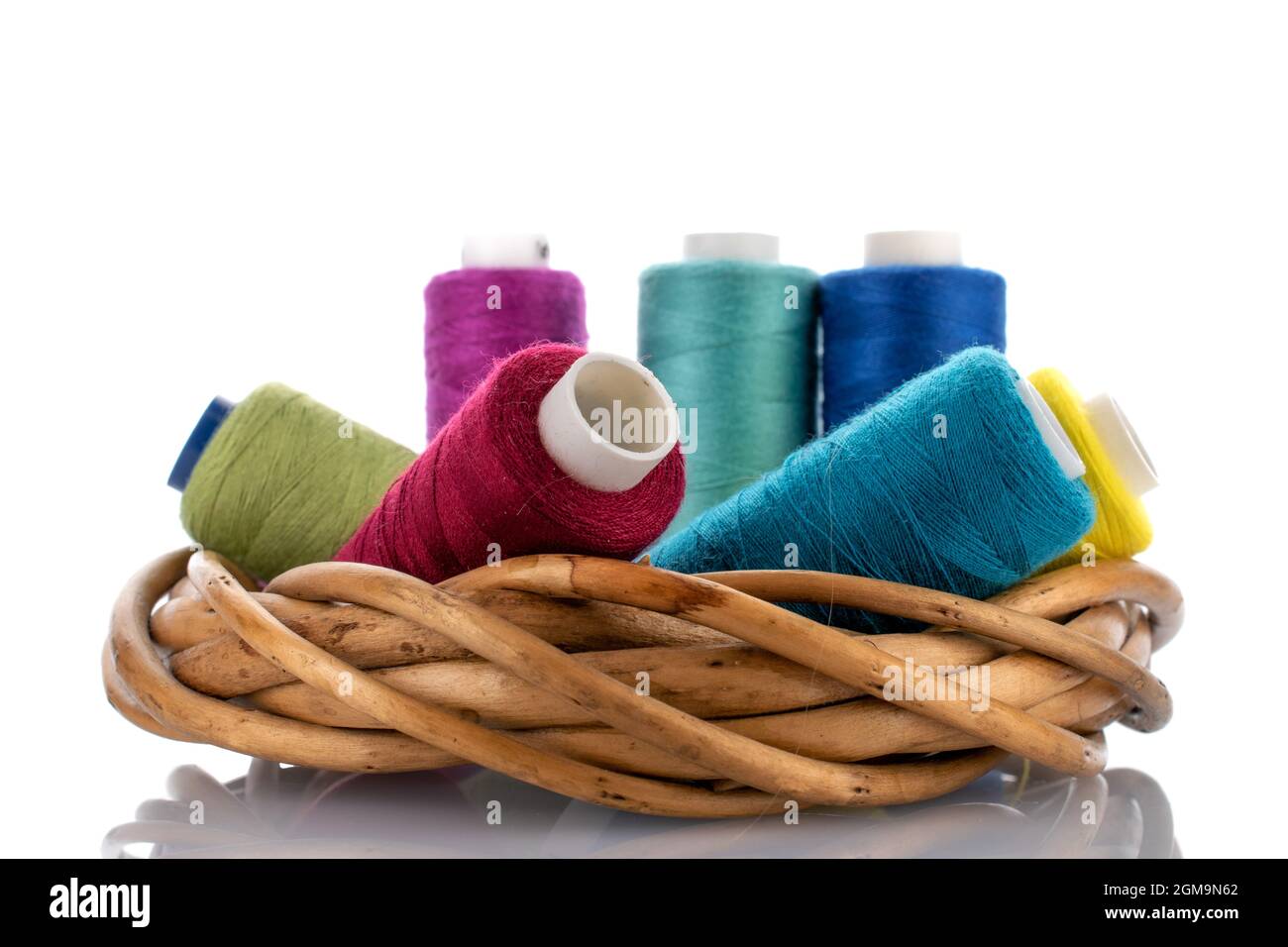 Several spool of colored thread with a wreath of vine, close-up ...