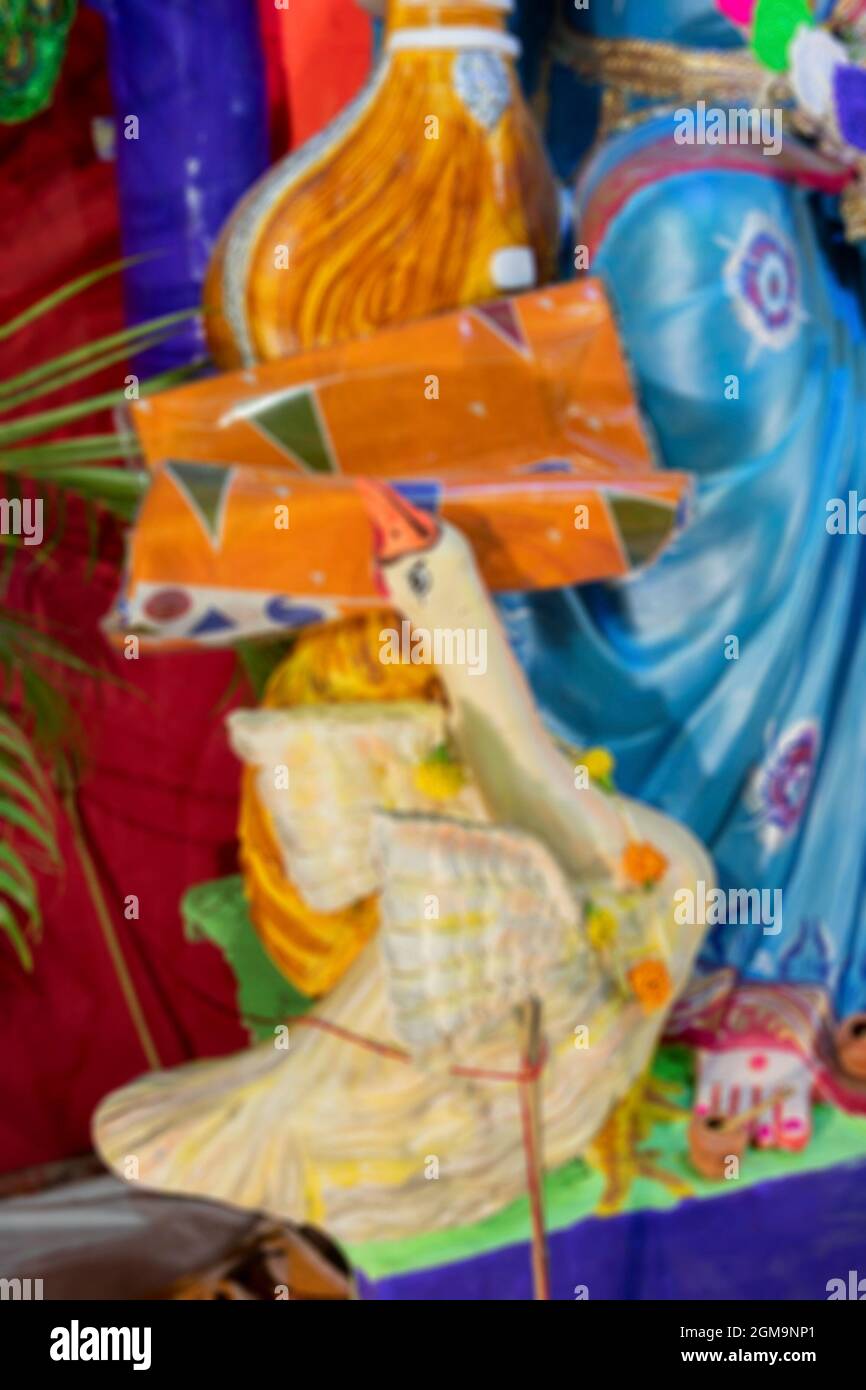 Blurred image of hamsa or swan clay idol near feet of Goddess Saraswati ...