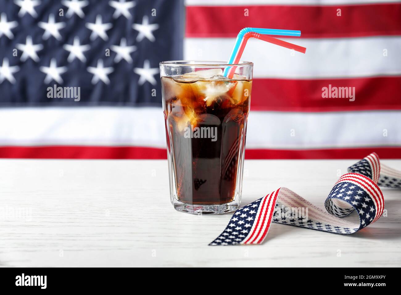Glass of cold cola on table against flag of the USA Stock Photo - Alamy