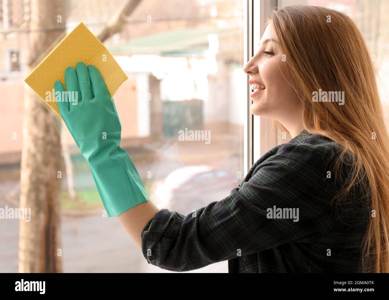Young woman cleaning window indoors Stock Photo - Alamy
