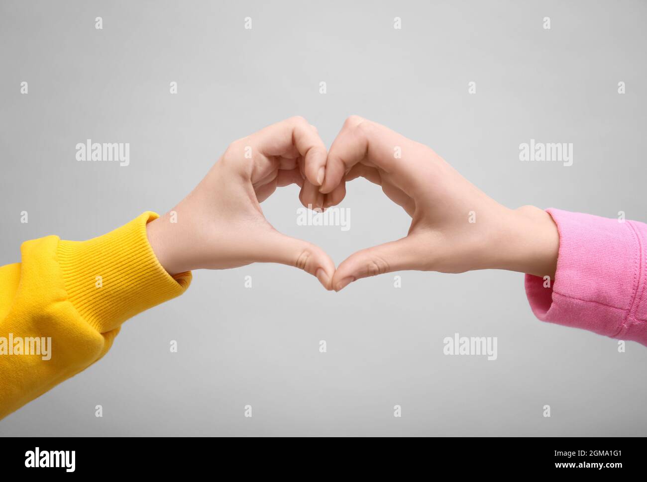 People making heart symbol with their hands on light background Stock ...