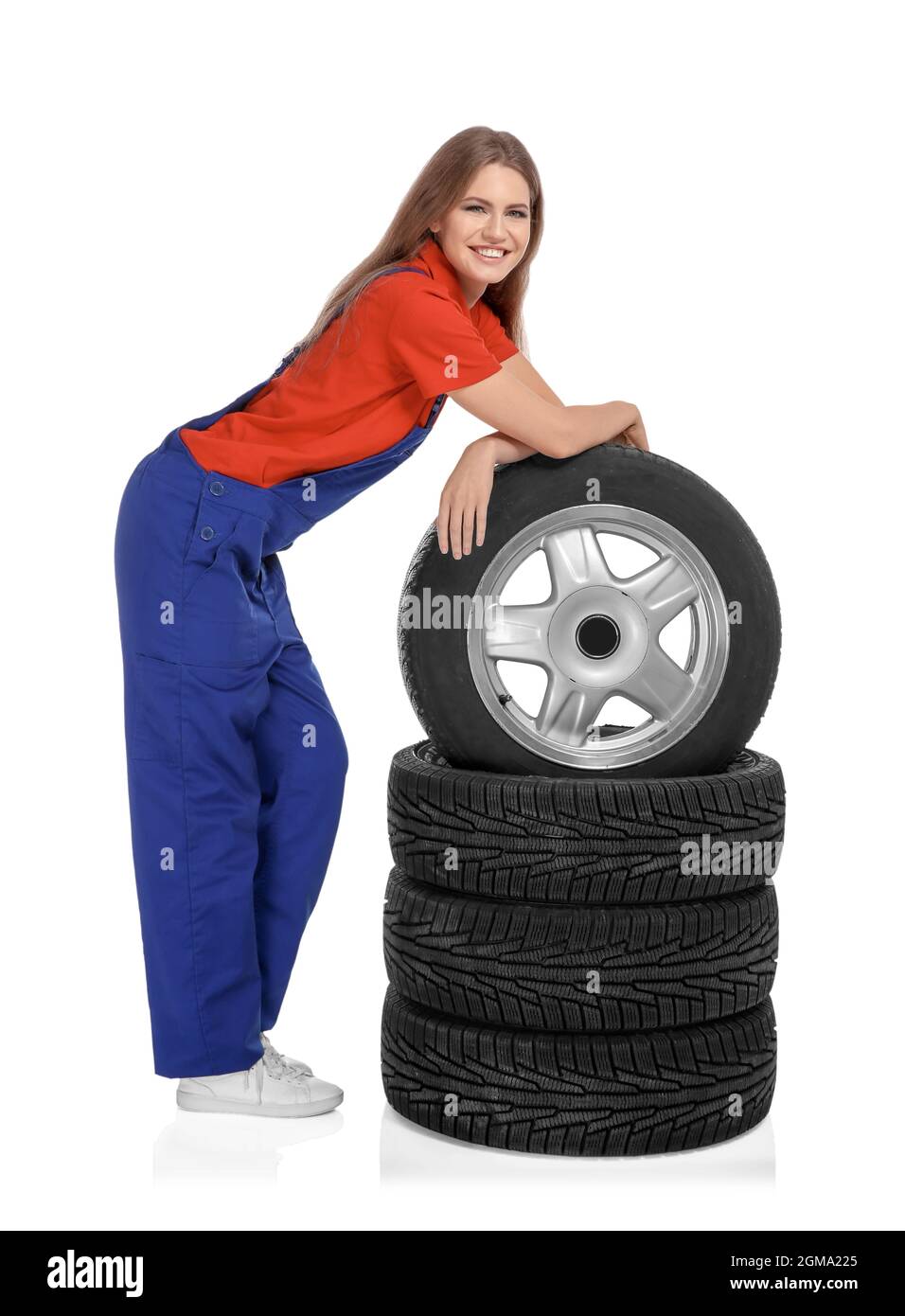 Female mechanic in uniform with car tires on white background Stock ...