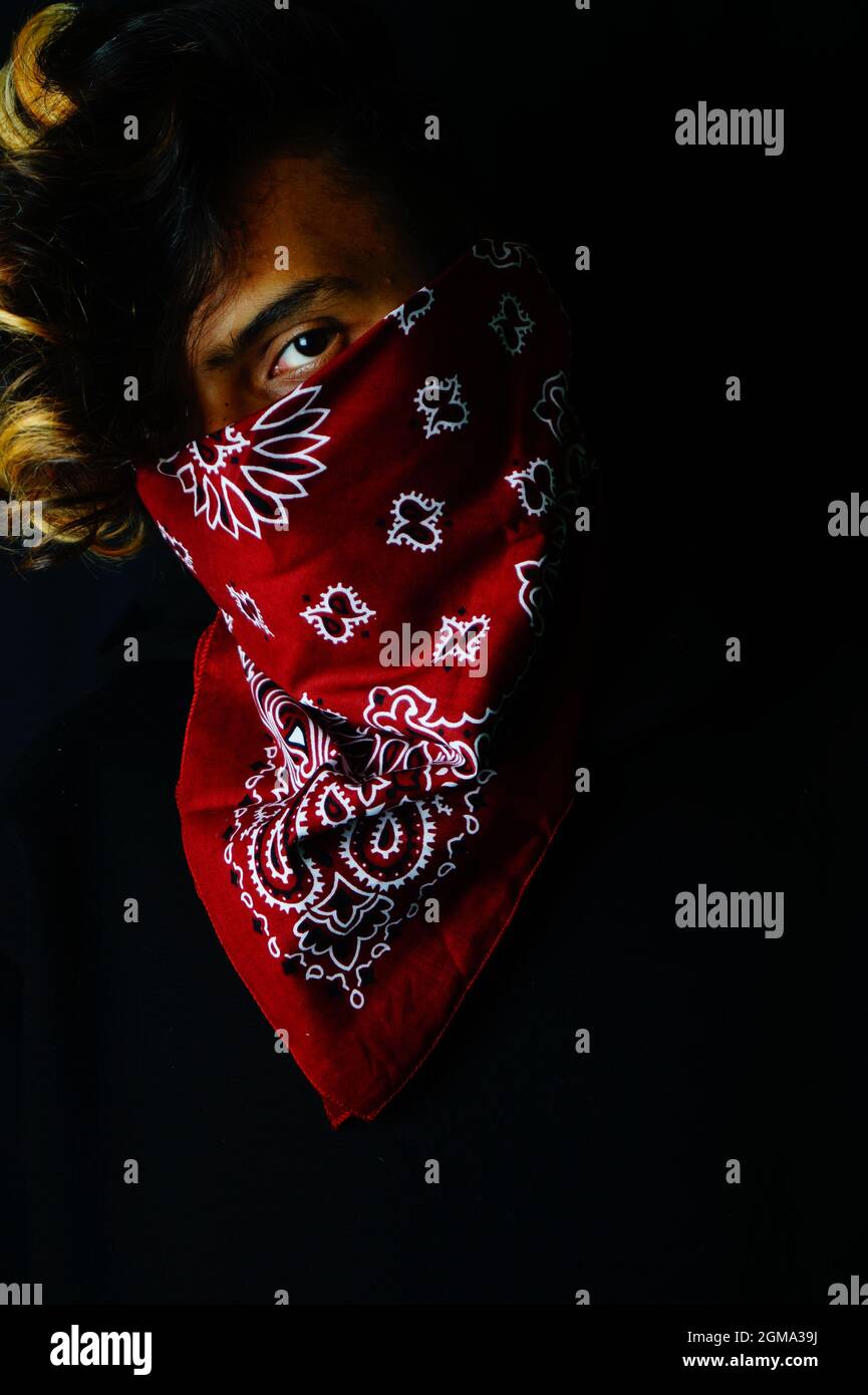 Closeup of a stylish Indian male wearing a red bandana over his face ...