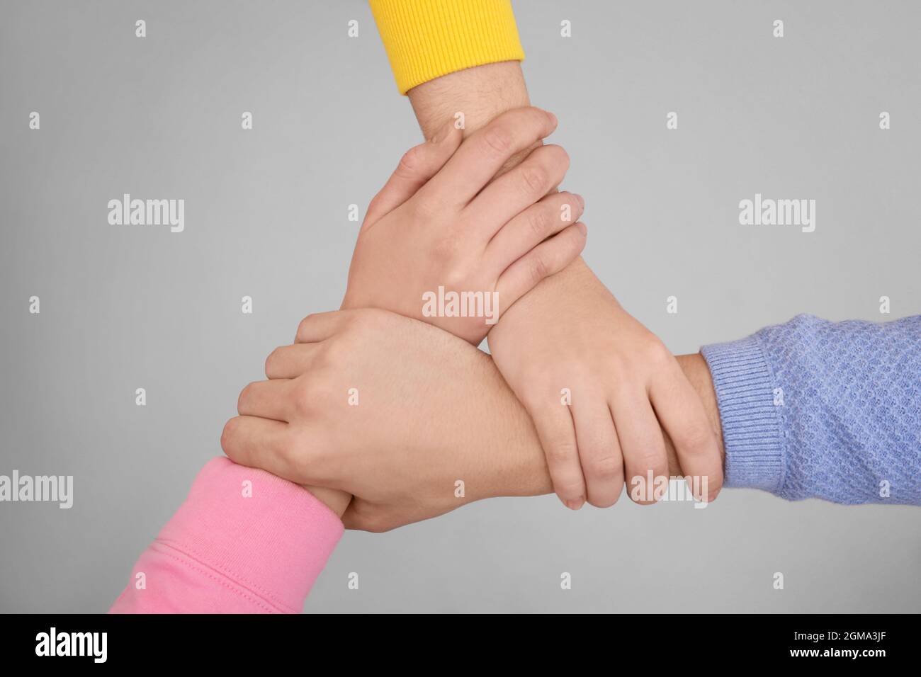People holding hands together on light background. Unity concept Stock ...