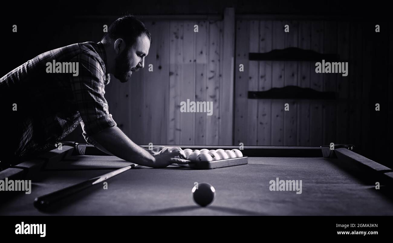A man with a beard plays a big billiard. Party in 12-foot pool ...