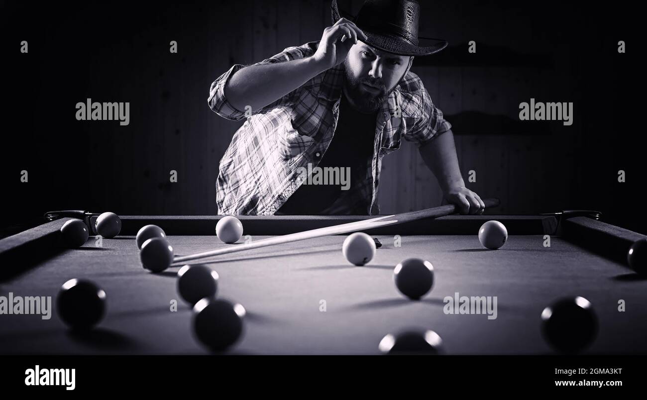 A man with a beard plays a big billiard. Party in 12-foot pool ...