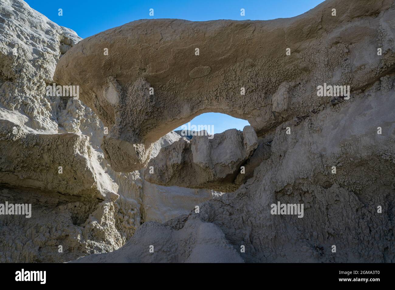 Blue sky frames the holes and crevices of the Bisti Badlands sandstone ...