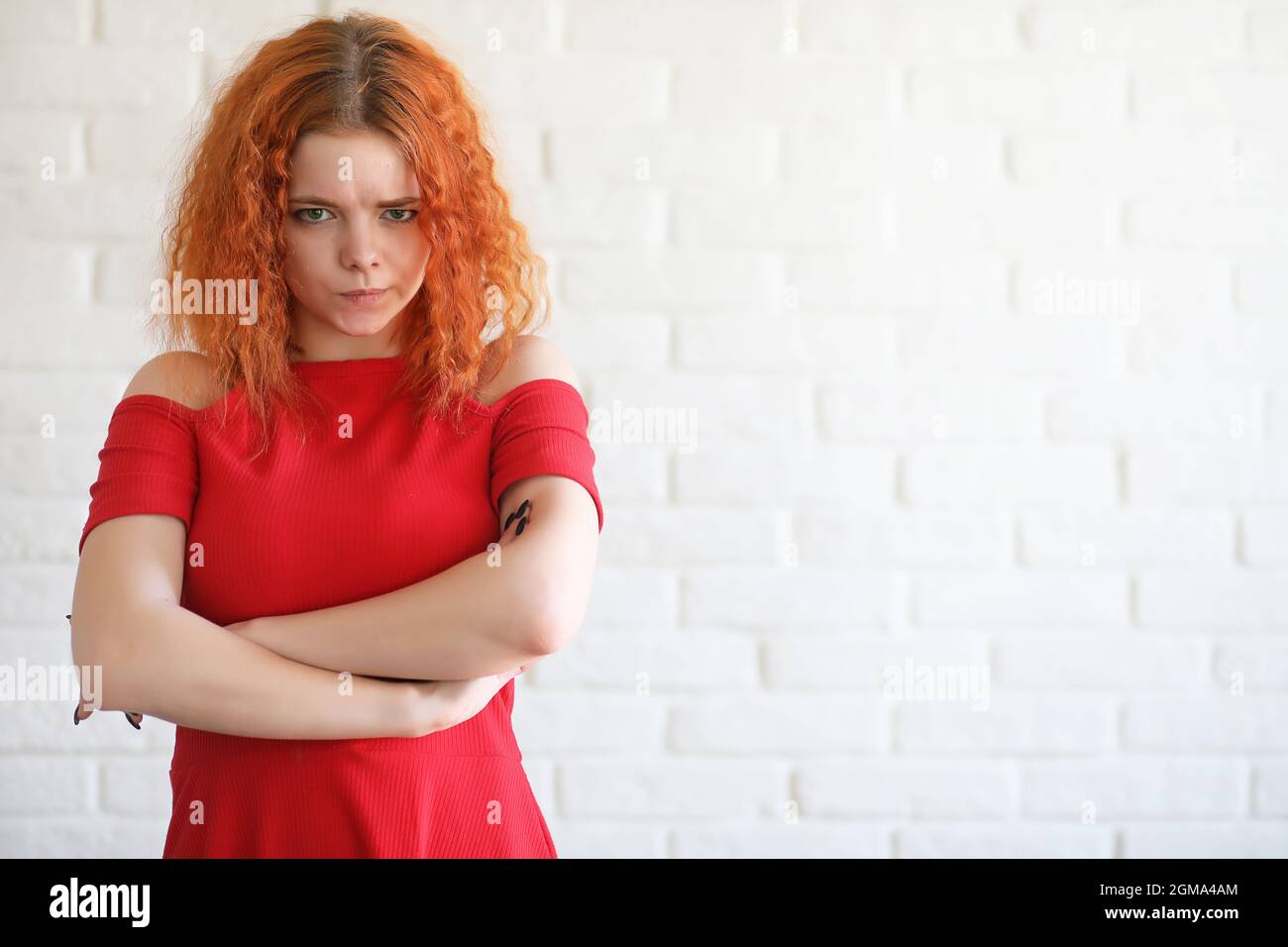Red-haired girl student on a brick wall background Stock Photo - Alamy