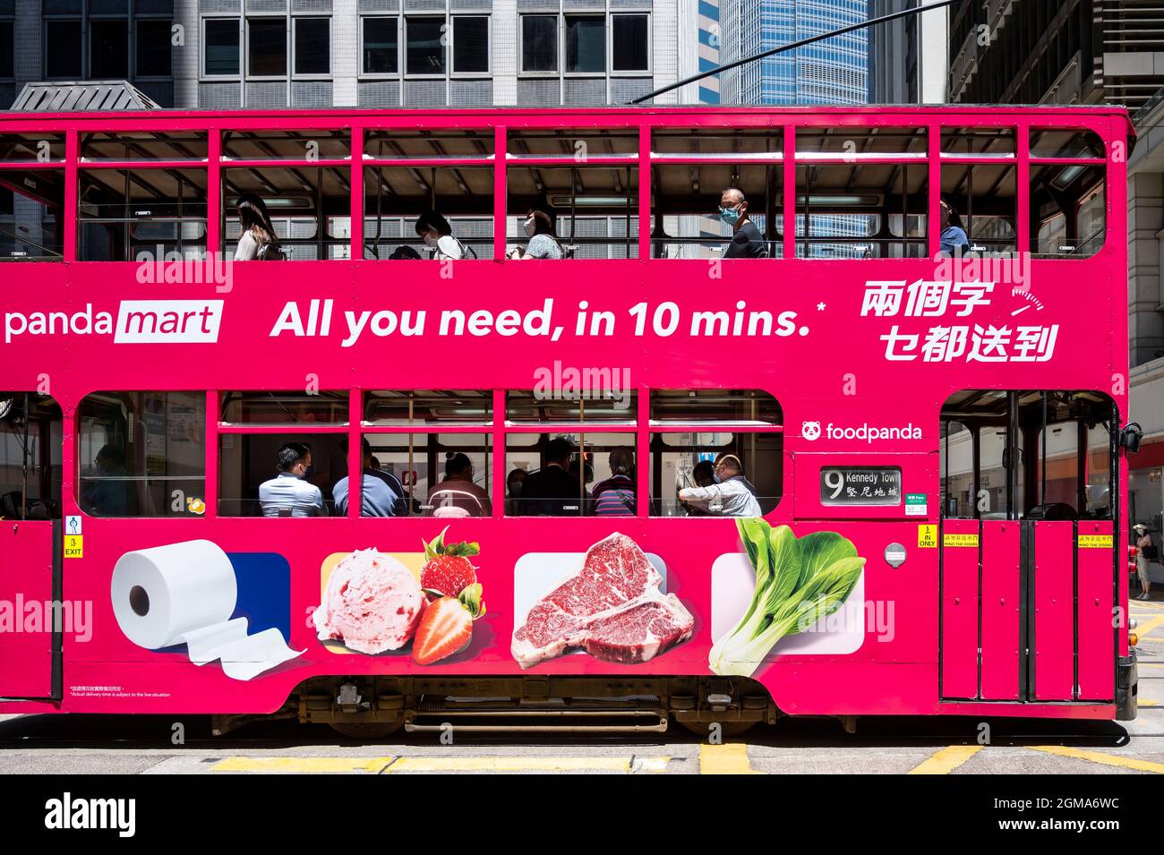 A double-deck tram runs covered with the delivery take out food company ...