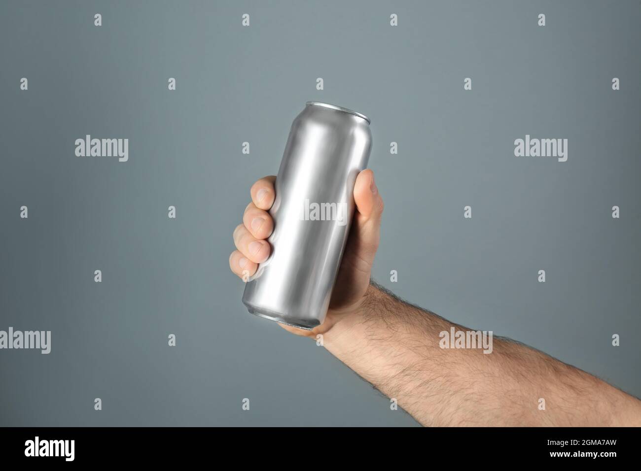 Man holding tin can on grey background Stock Photo - Alamy