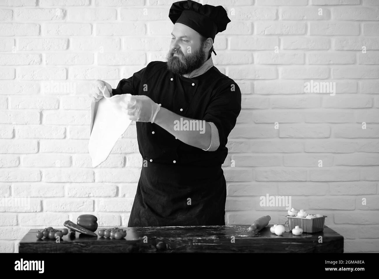 Bearded chef chef prepares meals at the table in the kitchen Stock ...