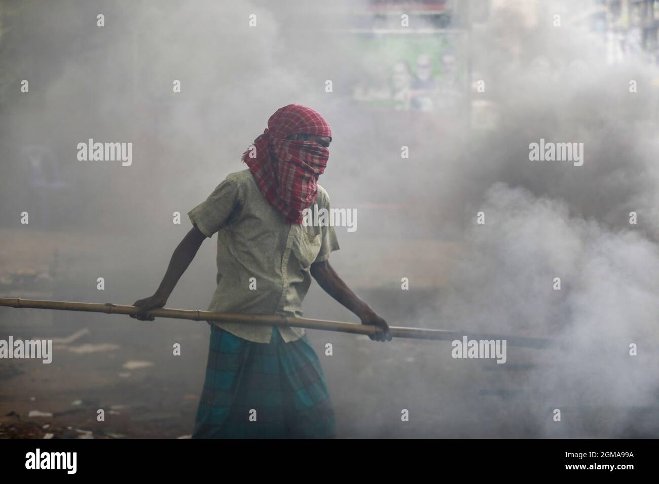 A Bangladeshi worker works at a road construction site in Dhaka ...