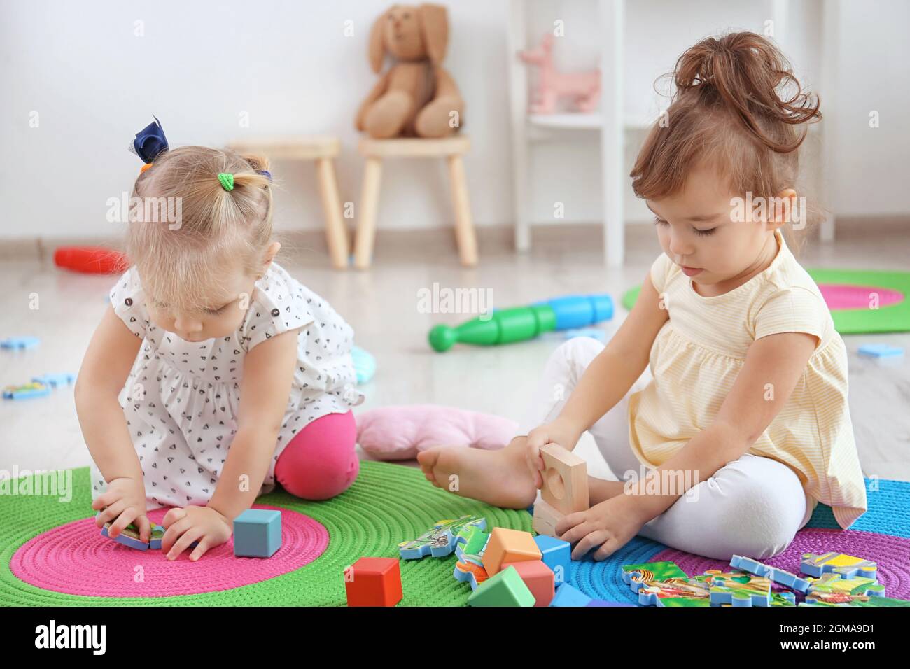 Adorable little children playing indoors Stock Photo - Alamy