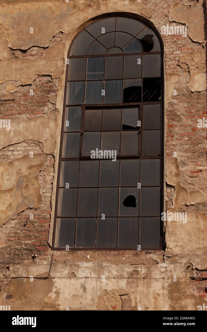 Arch-shaped paned window with damaged glass Stock Photo - Alamy