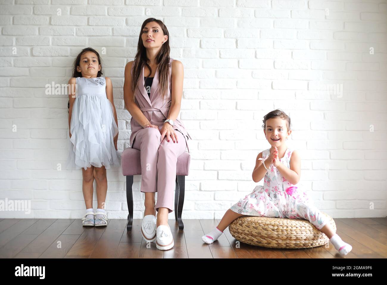 Beautiful young family with daughters at a photo shoot in a white ...