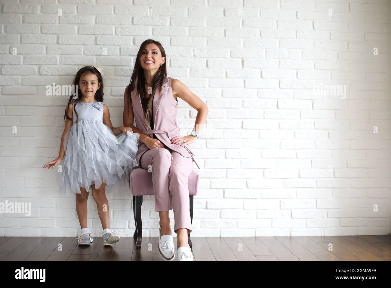 Beautiful young family with daughters at a photo shoot in a white ...