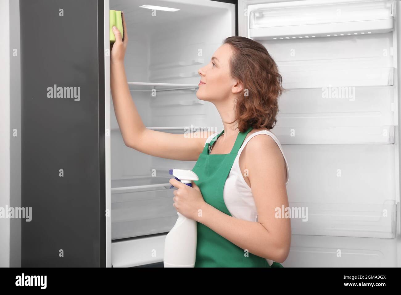 Beautiful woman cleaning empty refrigerator in kitchen Stock Photo - Alamy