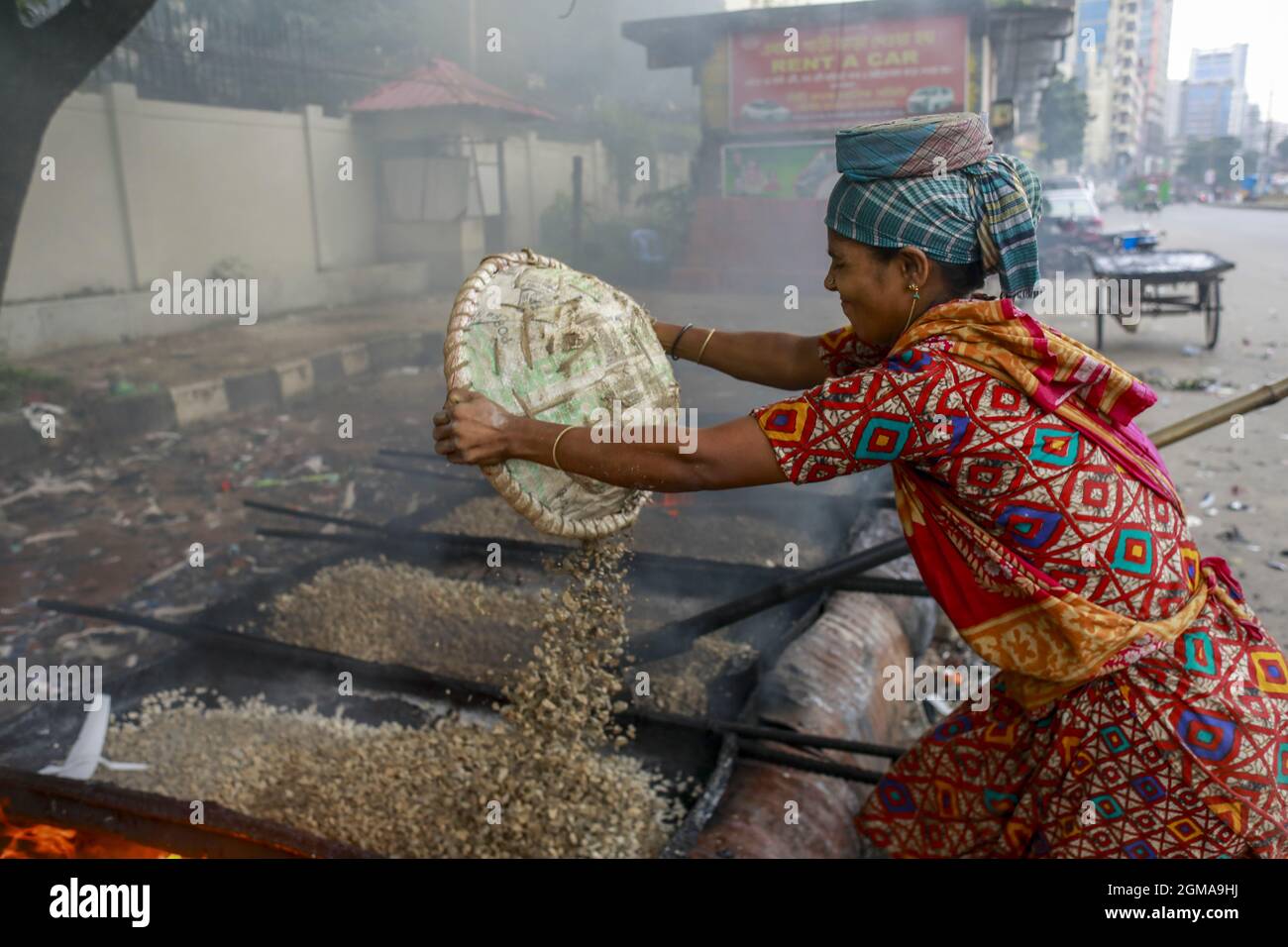 A Bangladeshi worker works at a road construction site in Dhaka ...