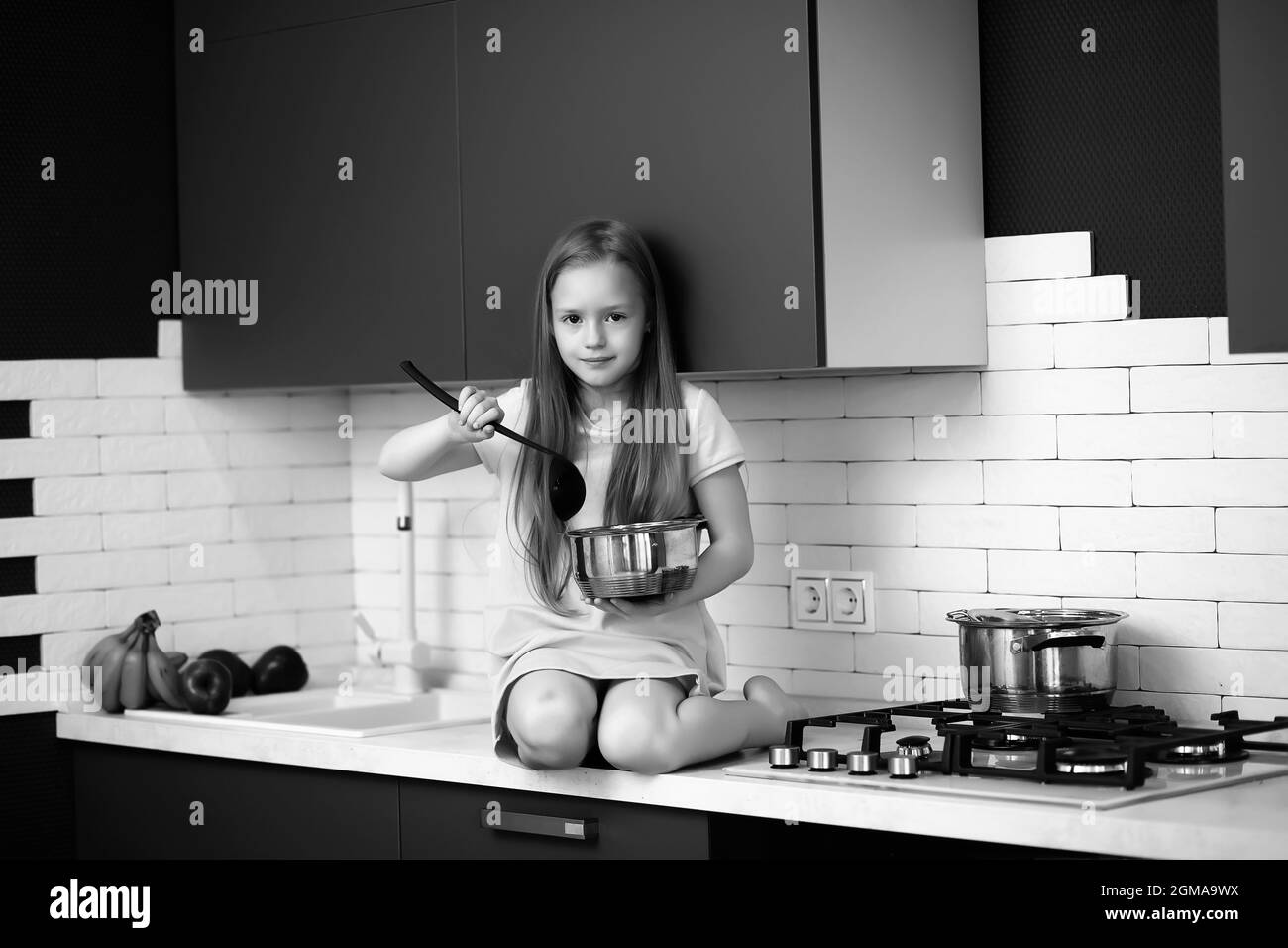 Little girl in the kitchen with cooking equipment Stock Photo - Alamy