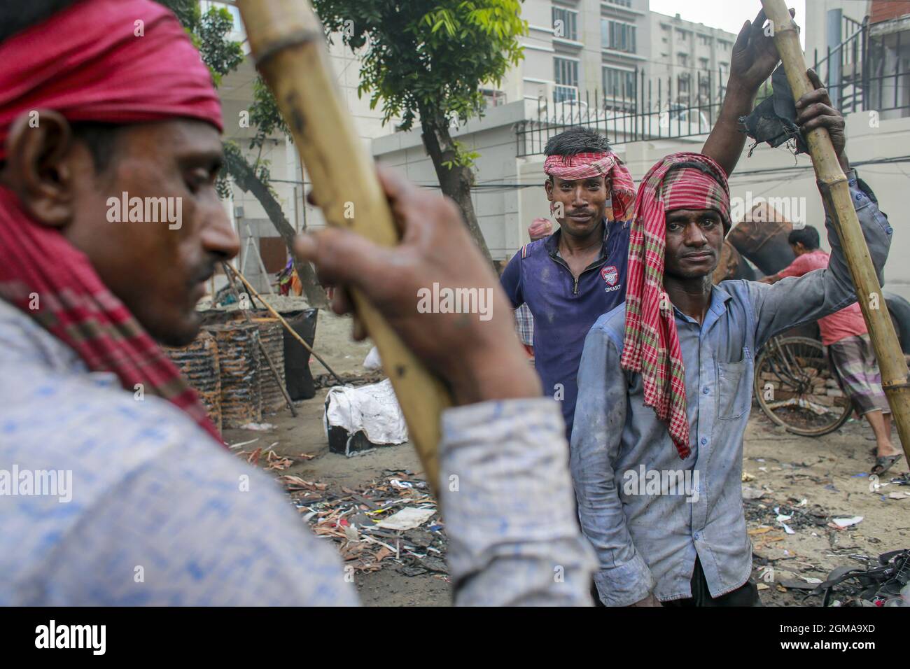 Bangladeshi workers work at a road construction site in Dhaka ...