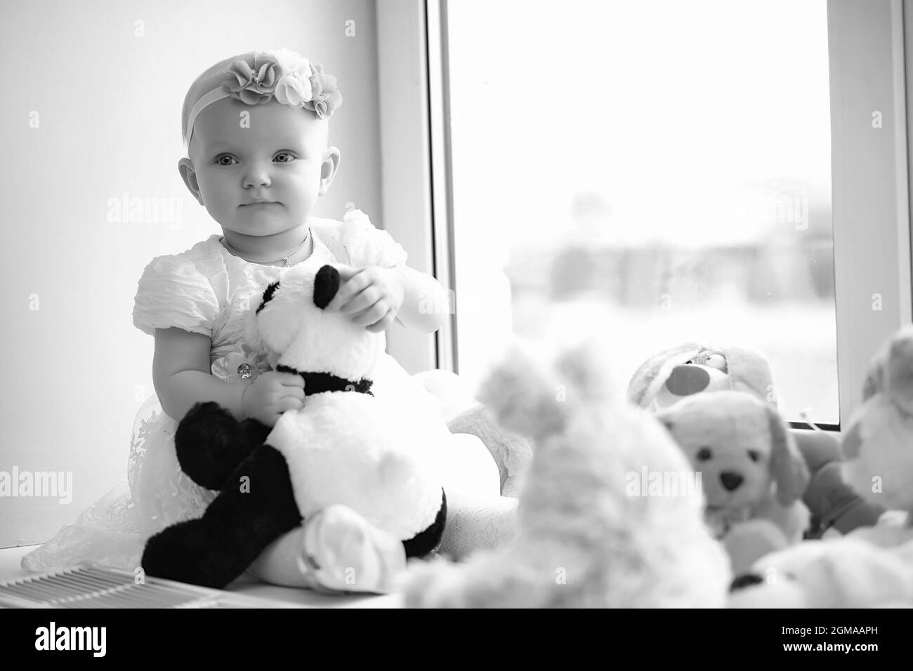 Child in the children's room. The kid is sitting on the windowsill at ...