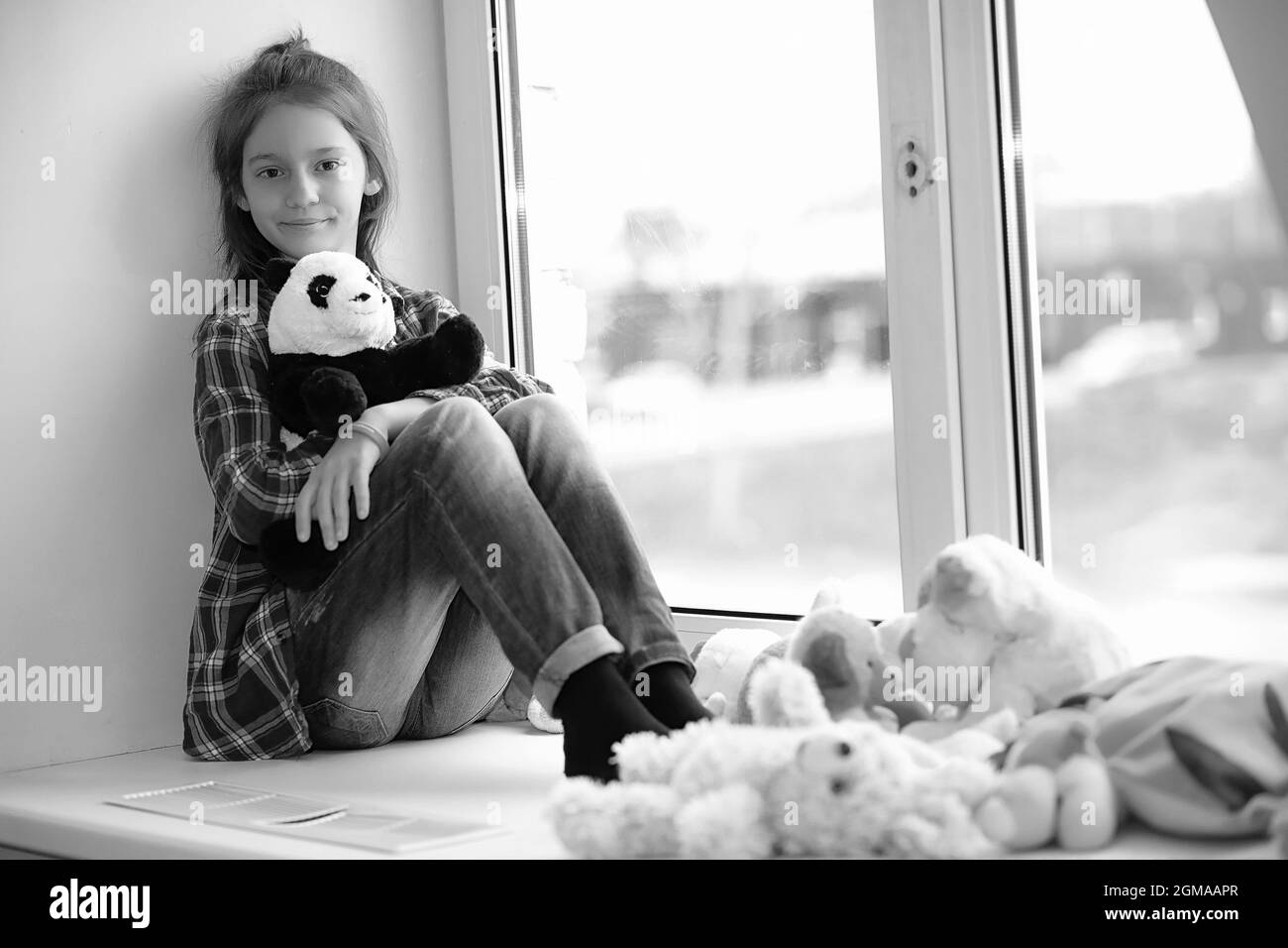 Child in the children's room. The kid is sitting on the windowsill at ...