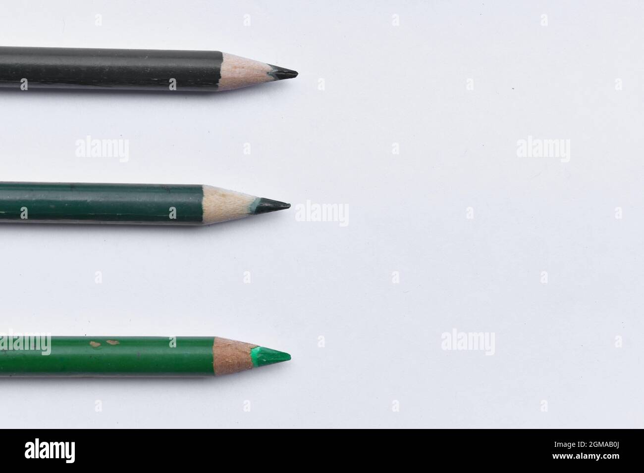 Parallel colored pencils in shades of green isolated on a white ...