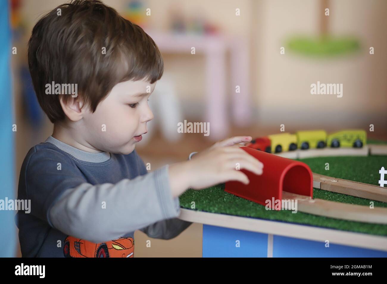 Child in the children's room. The kid is sitting on the windowsill at ...