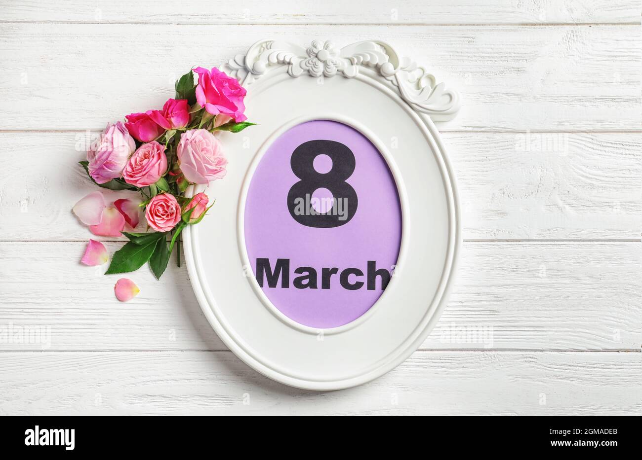 Frame with phrase "8 March" and roses on wooden background ...