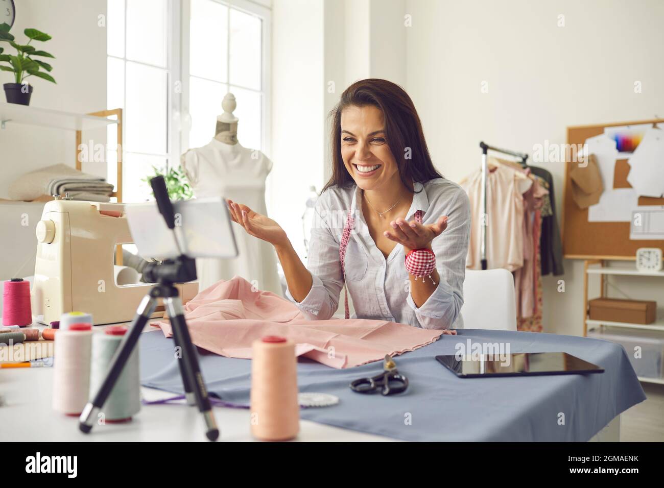 Happy female video blogger giving an online sewing workshop on how to ...