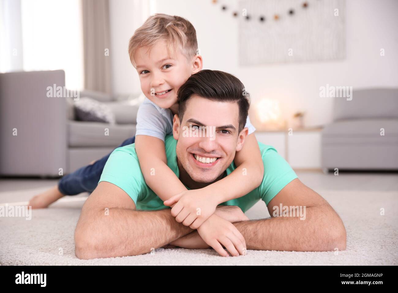 Young man and little boy indoors. Child adoption Stock Photo - Alamy