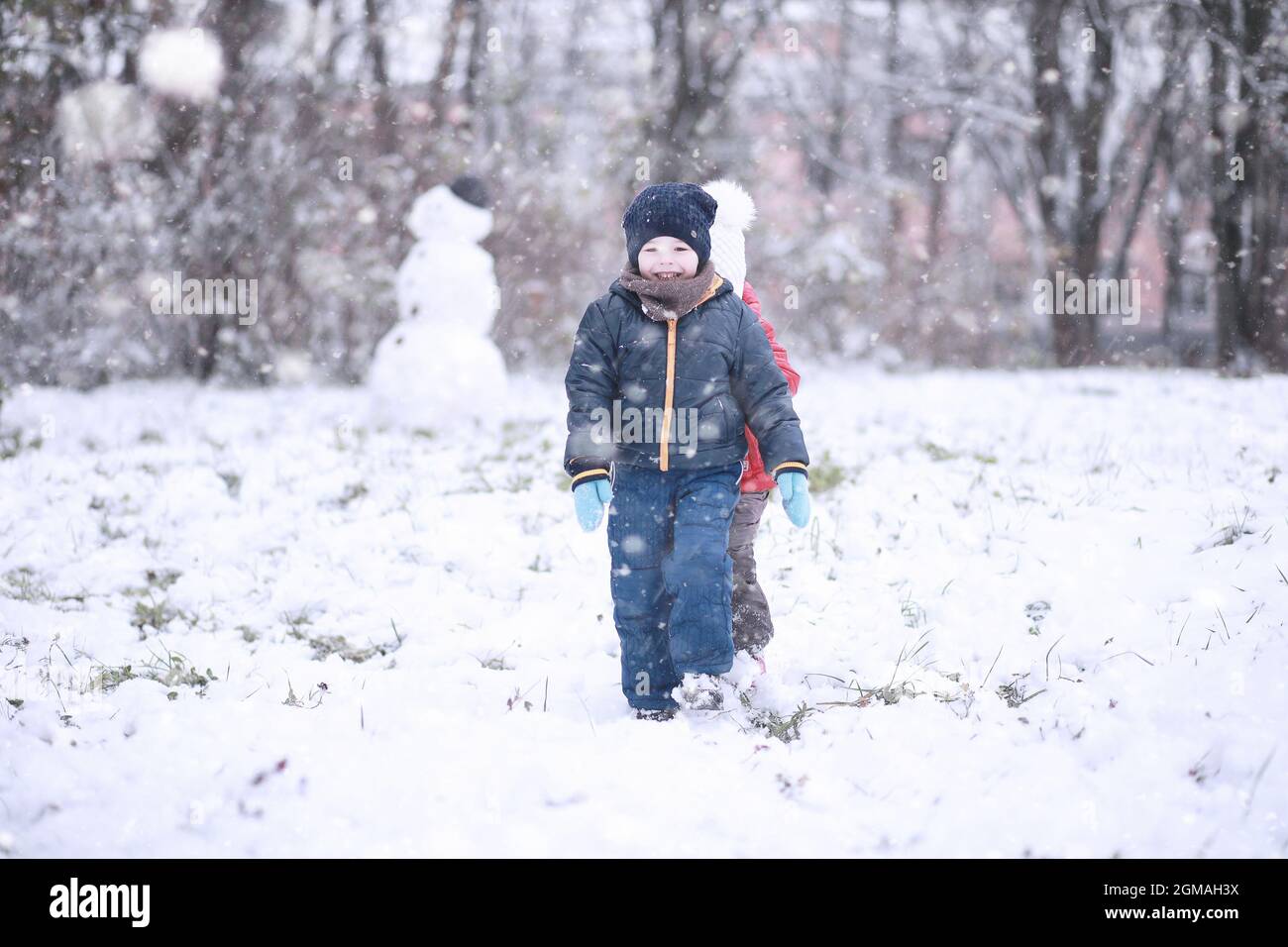 Kids walk in the park with first snow Stock Photo - Alamy